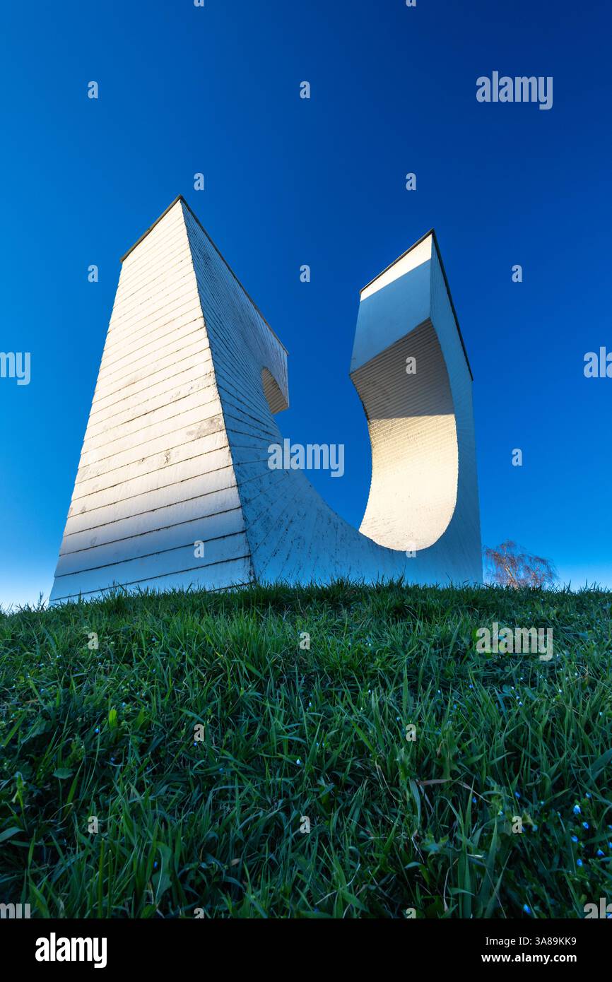 Modern white concrete monument featuring a circular design, set amid ...