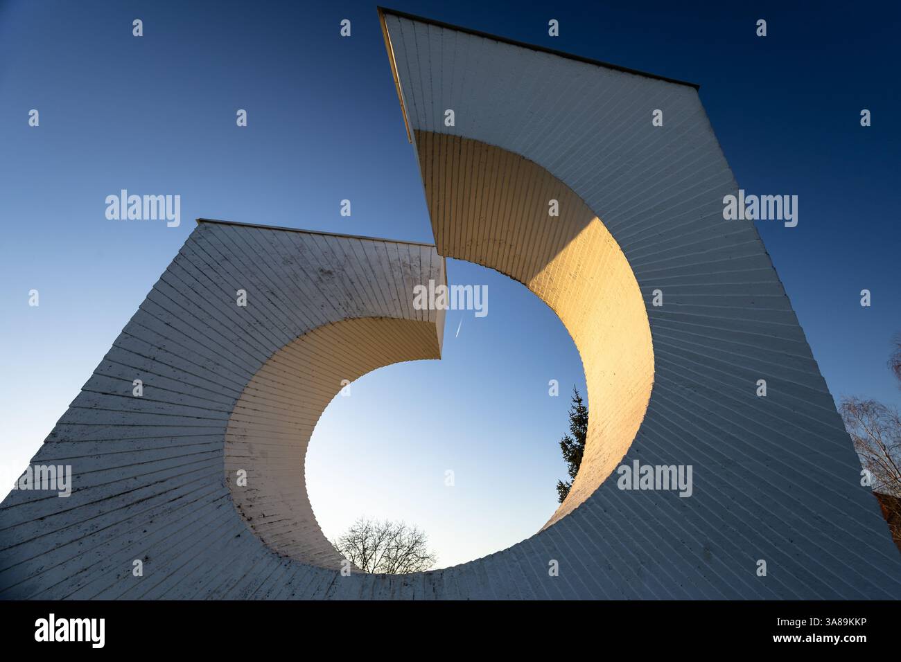 Modern white concrete monument featuring a circular design, set amid ...