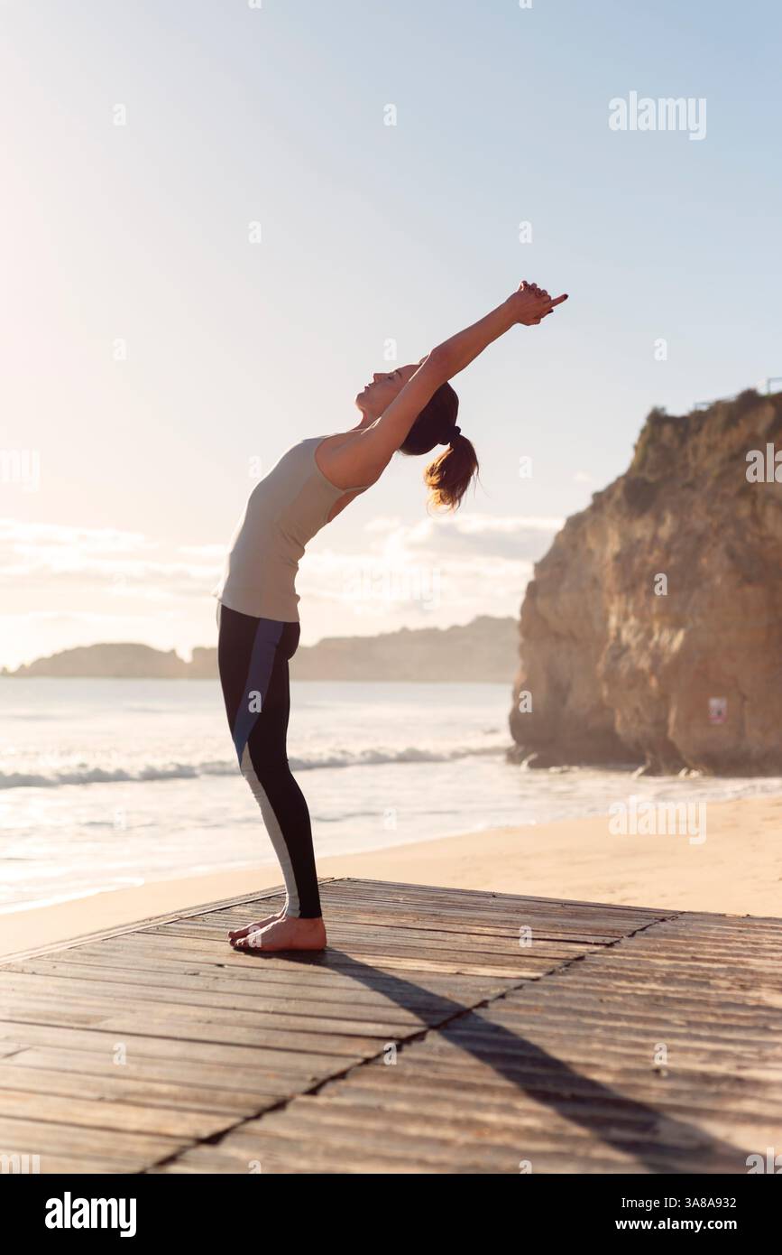 sporty woman practicing yoga at the beach, backbend Stock Photo - Alamy