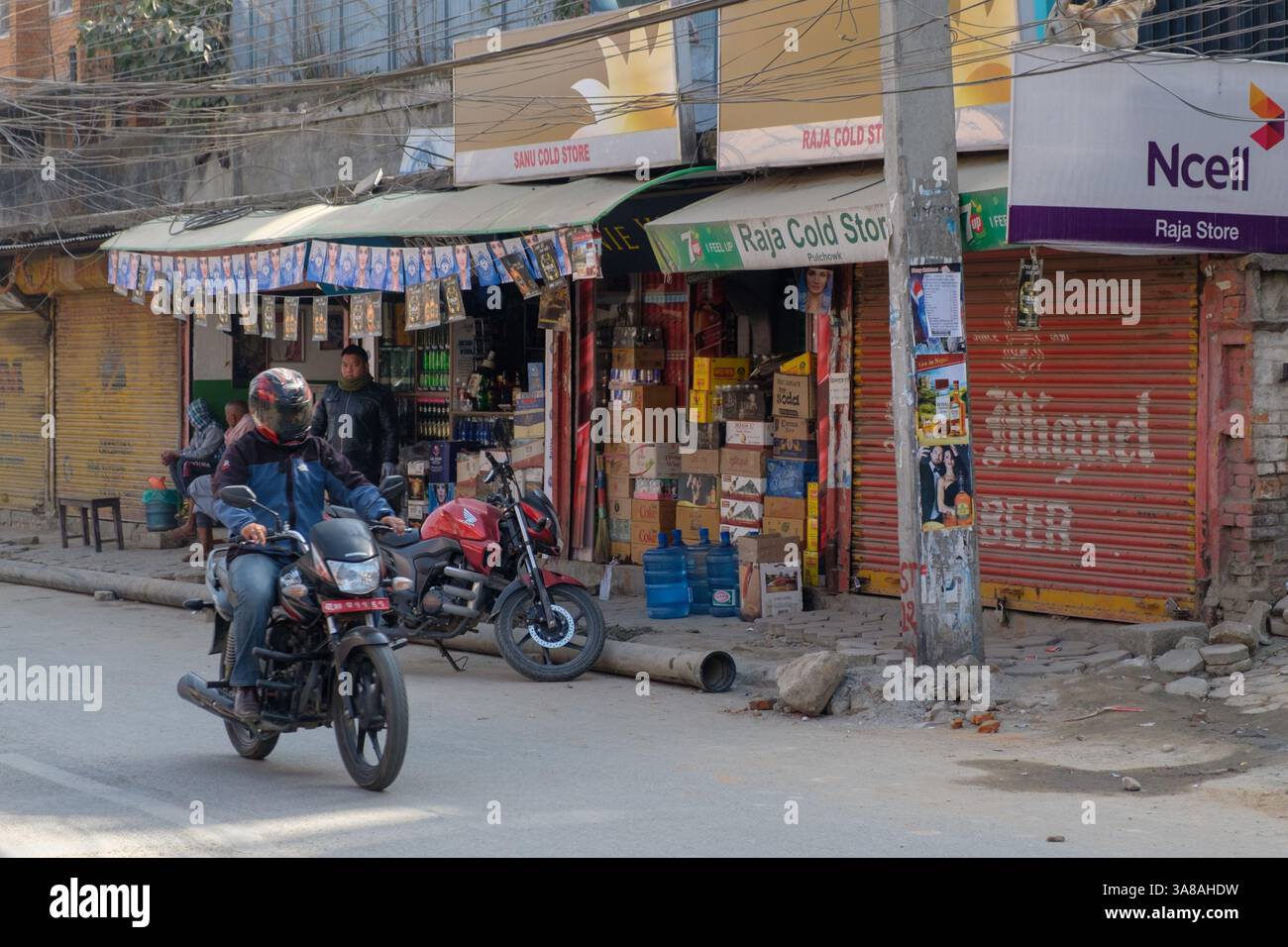 A motorcyclist rides past Raja Cold Store in Pulchowk, Nepal. People ...