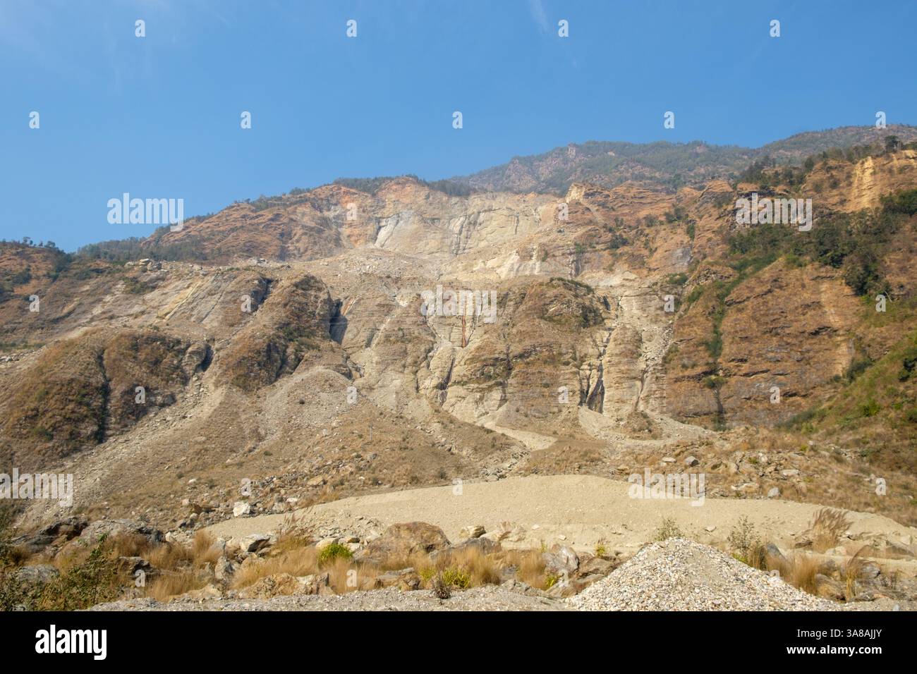 A steep mountainside displays significant scarring, likely from natural ...