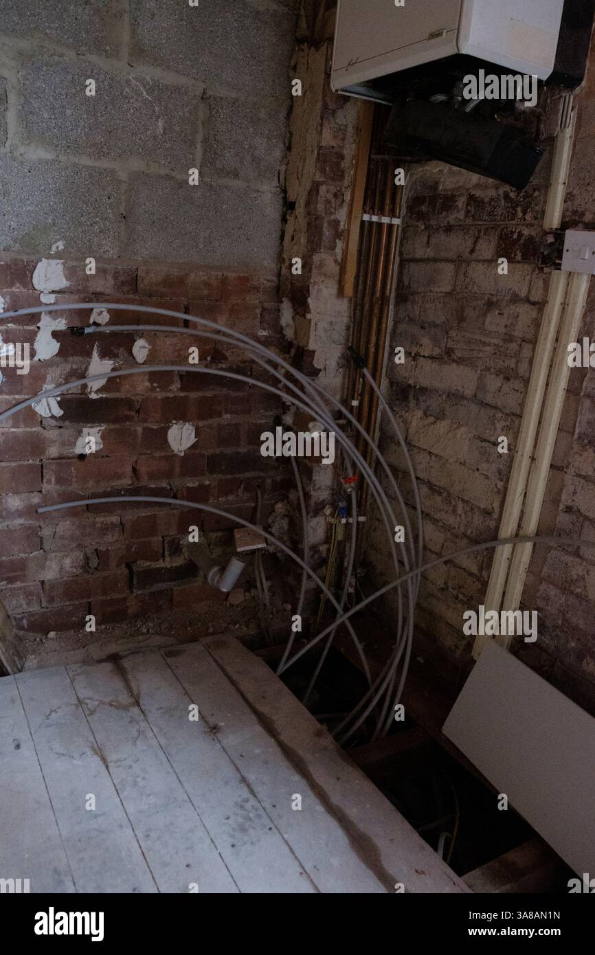 Renovation underway: New plumbing pipes run along exposed brick/block ...