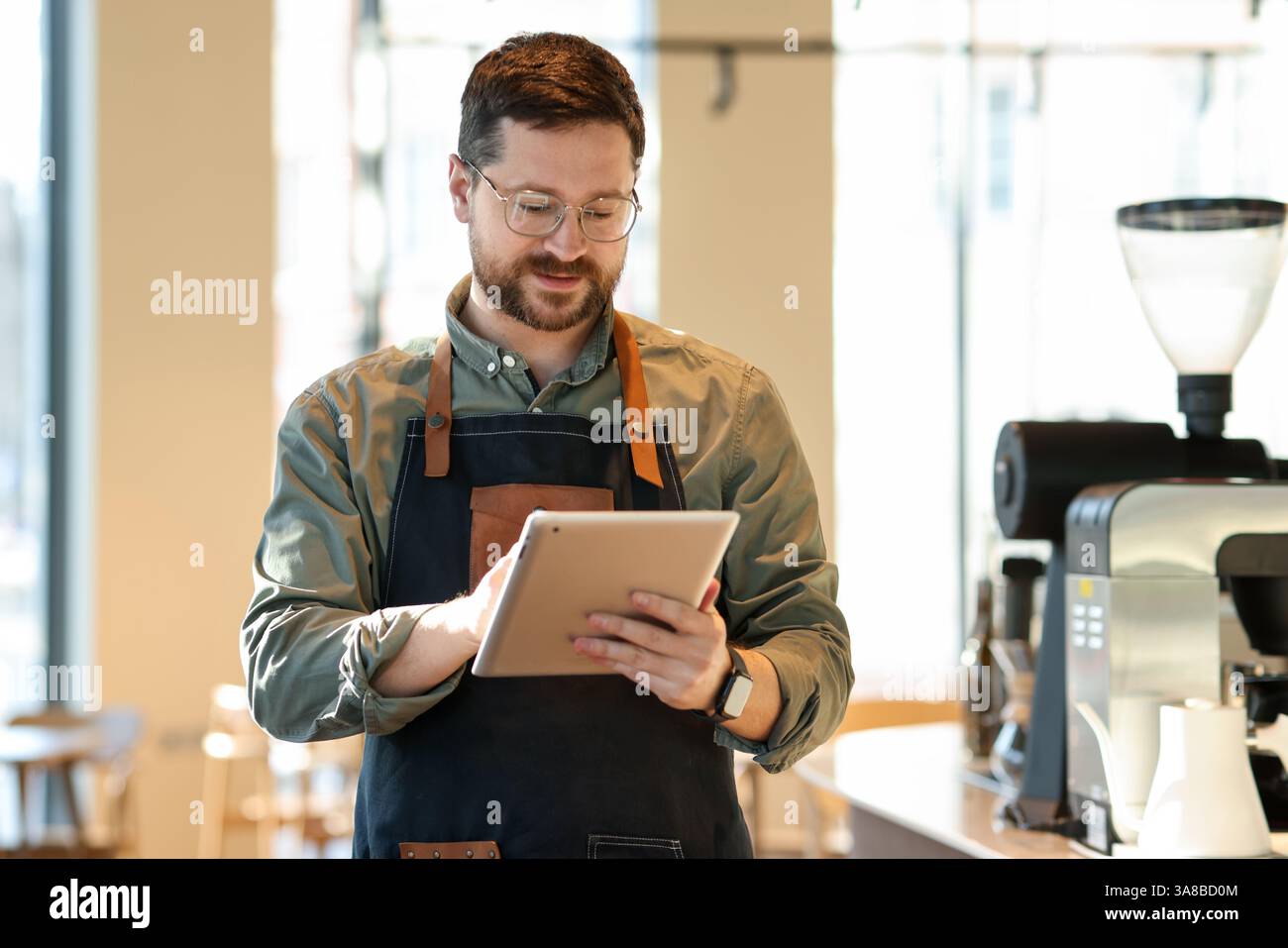 Handsome business owner working with tablet in his cafe Stock Photo - Alamy