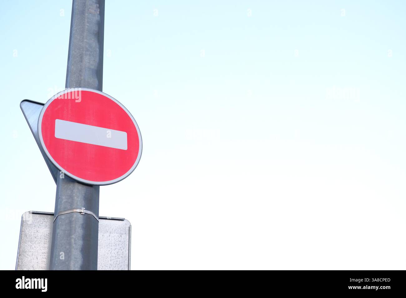 Red no-entry traffic sign on metal pole. Do not enter round sign for ...