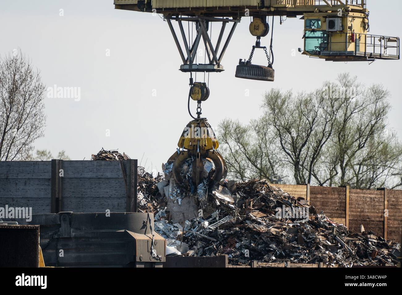 Kehl, Germany. 28th Mar, 2025. A grab transports scrap metal to a scrap ...