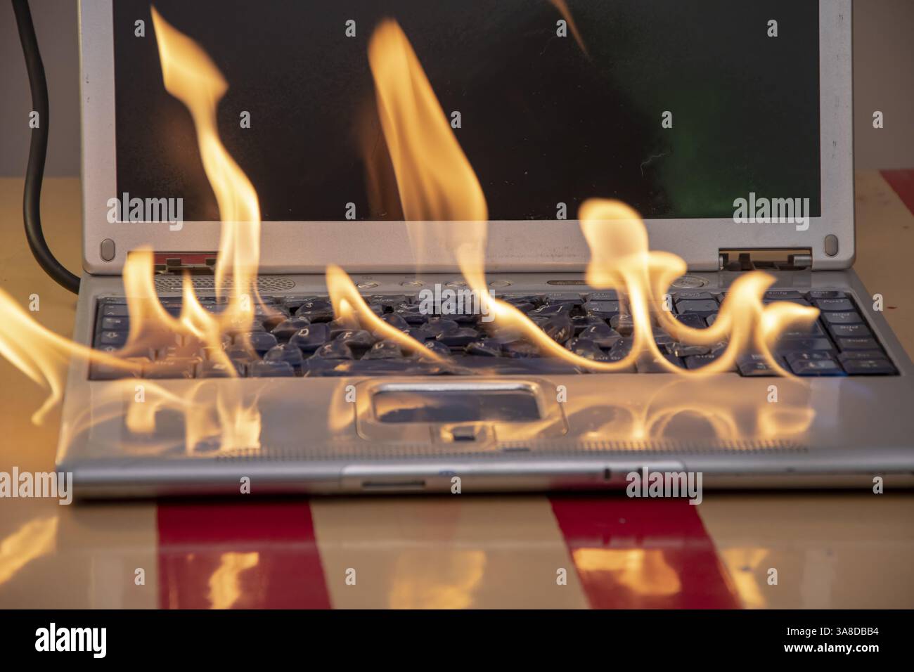 Electronics failure: laptop with melted keys and tongues of flame Stock ...