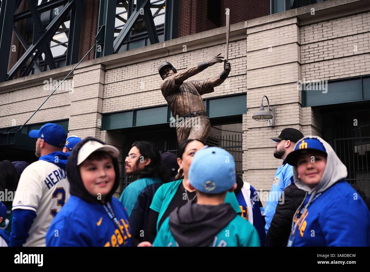 Fans line up outside T-Mobile Park and a statue of Seattle Mariners ...