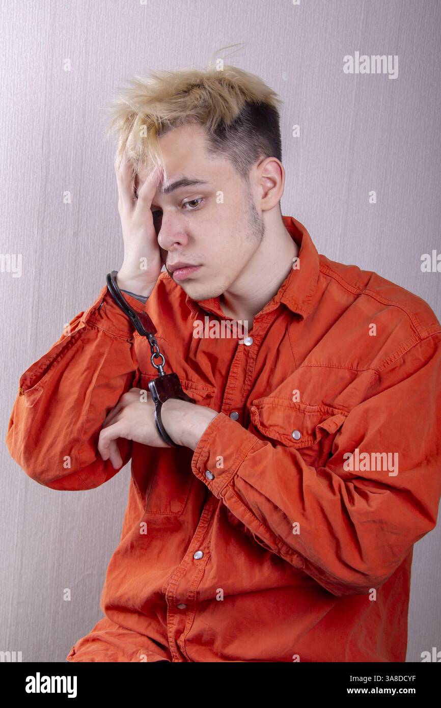 Arrested young man in custody wearing a prisoner's uniform Stock Photo ...