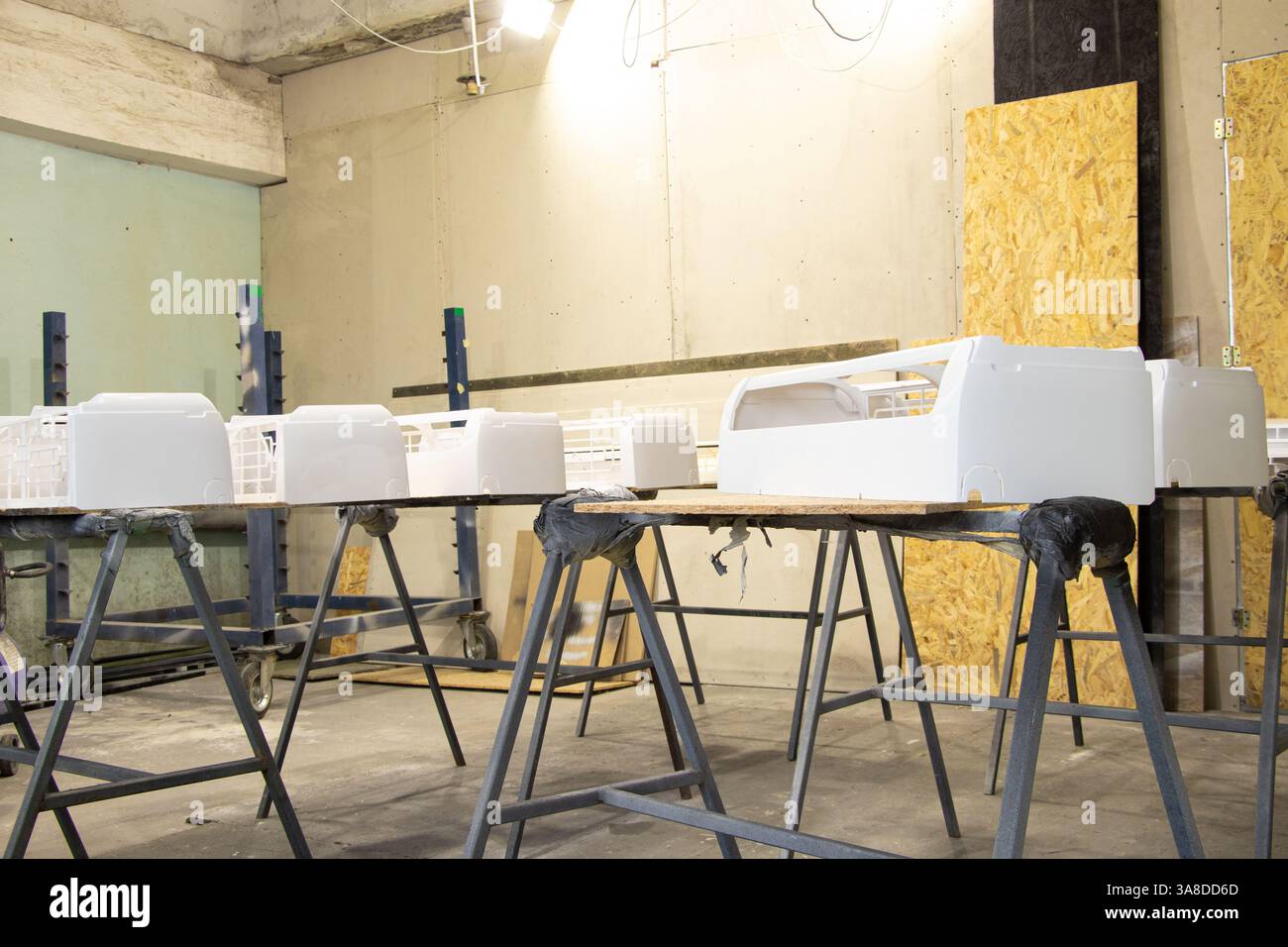 Paint shop, where air conditioner housings are laid out on tables for ...