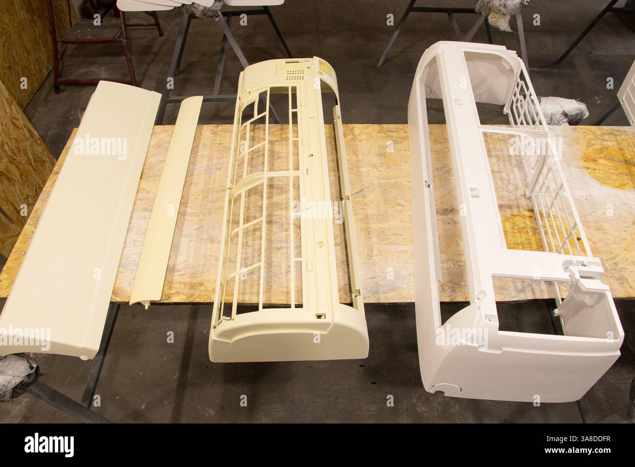 Paint shop, where air conditioner housings are laid out on tables for ...