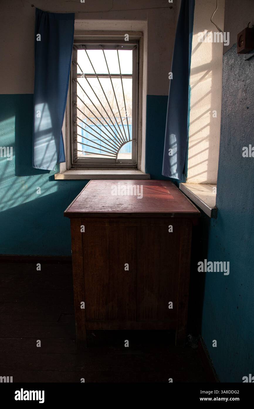 A room with bars on the windows and a bedside table with old repairs ...