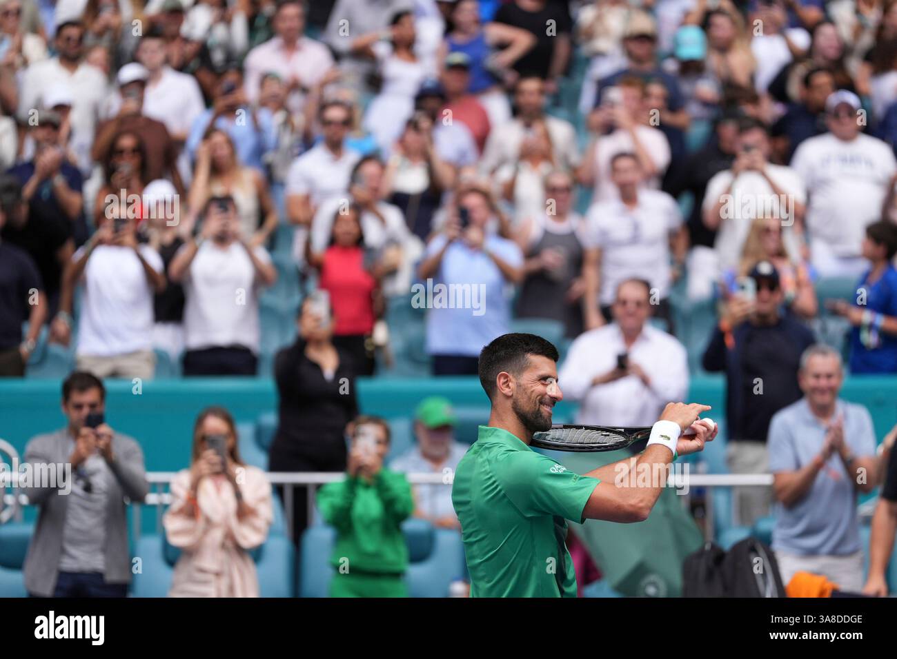 Novak Djokovic, of Serbia, mimes playing a violin with his racket as he ...