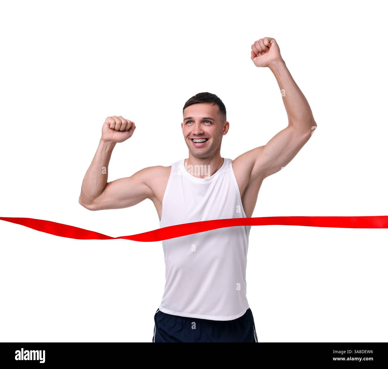 Happy sportsman crossing red finish line ribbon on white background ...