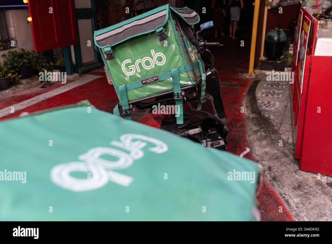 A Grab food delivery rider motorcycle parked in the busy streets Stock ...