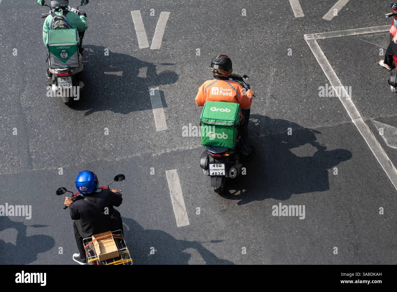 A Grab food delivery motorcycle rider drives through traffic Stock ...