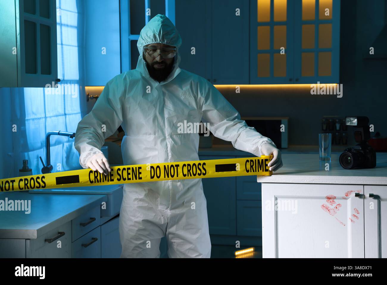 Forensic expert blocking way to crime scene with yellow tape indoors ...