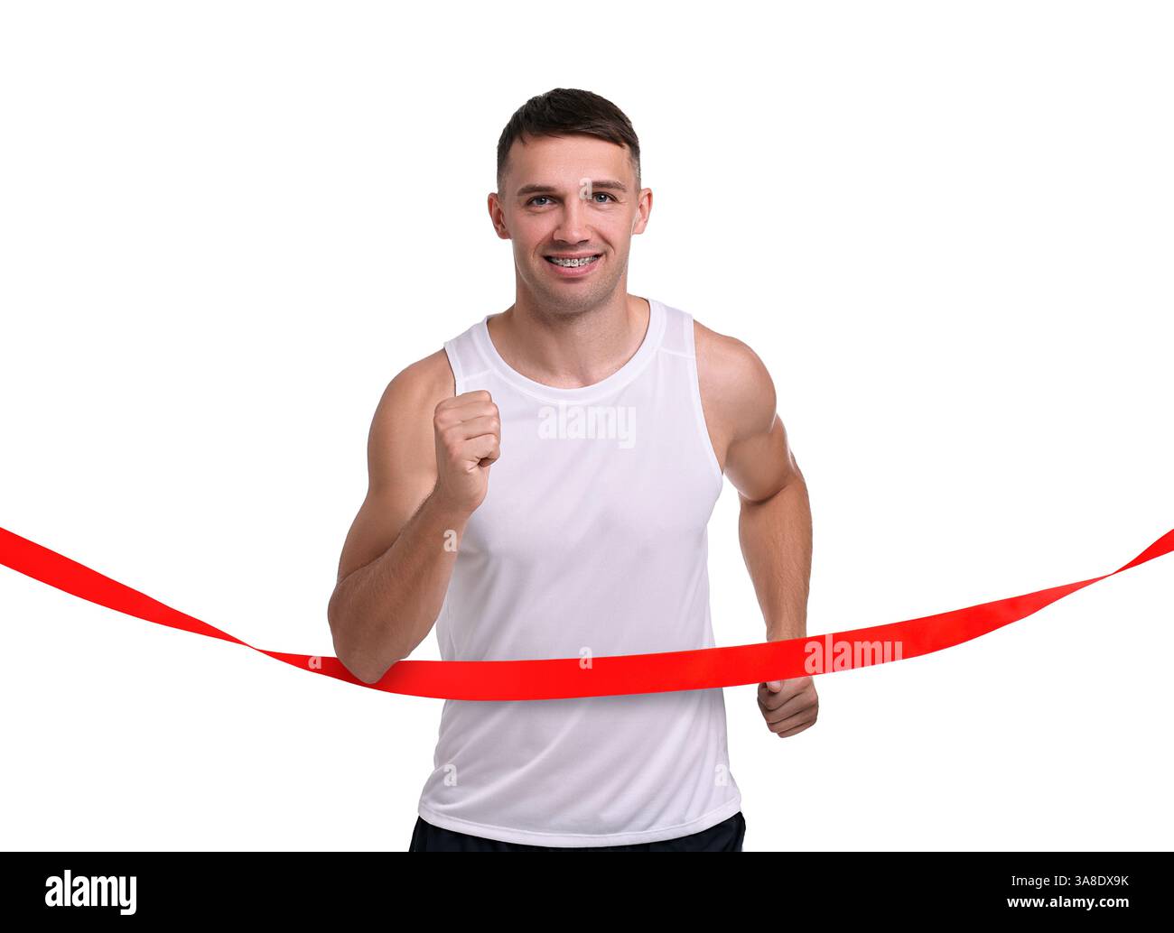 Happy sportsman crossing red finish line ribbon on white background ...