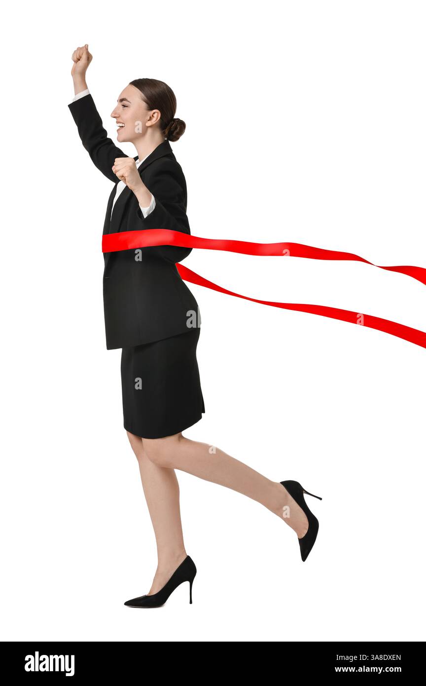 Happy businesswoman crossing red finish line ribbon on white background ...