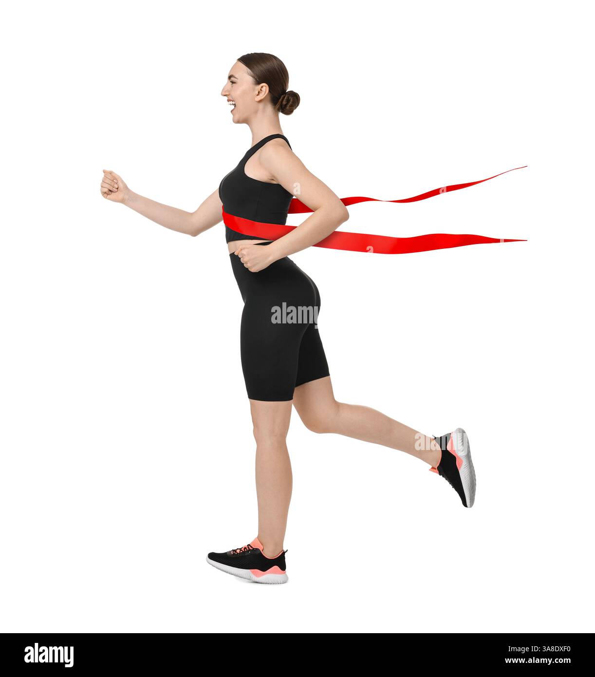 Happy sportswoman crossing red finish line ribbon on white background ...