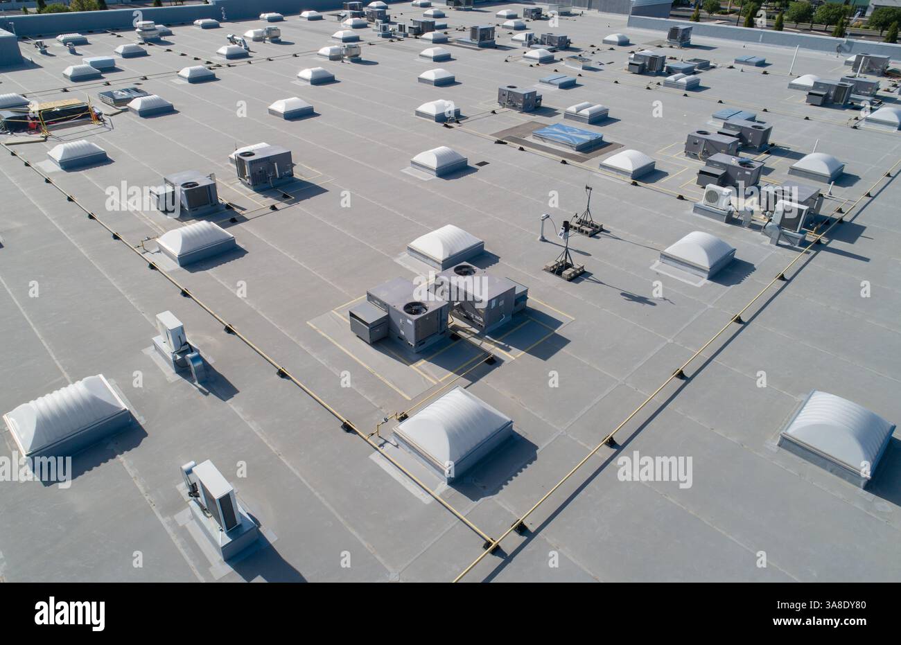 A large building with many vents and a roof. The roof is white and the ...