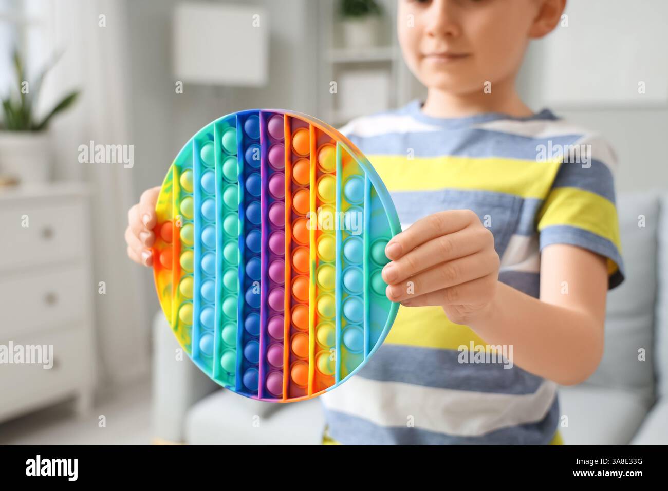 Little boy with autistic disorder and pop it fidget toy at home ...