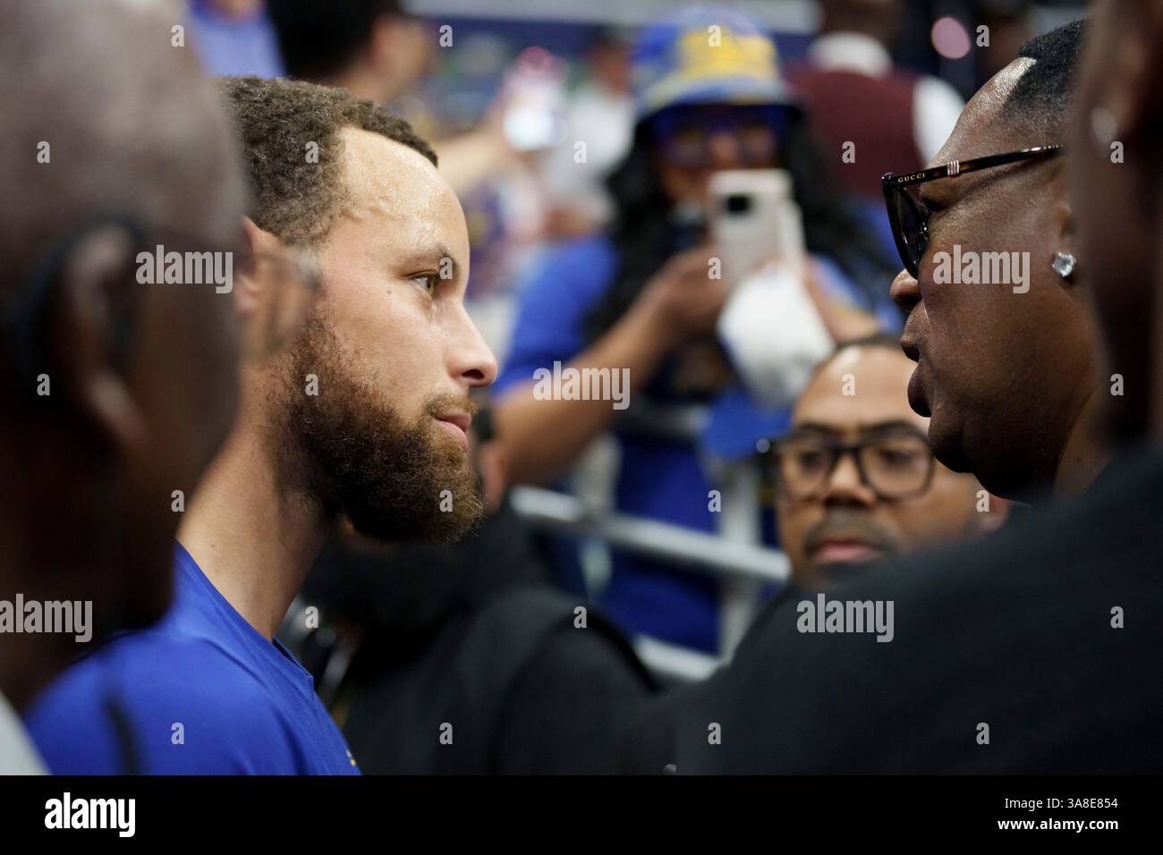Golden State Warriors guard Stephen Curry, left, greets rapper Percy "Master P" Miller, right ...