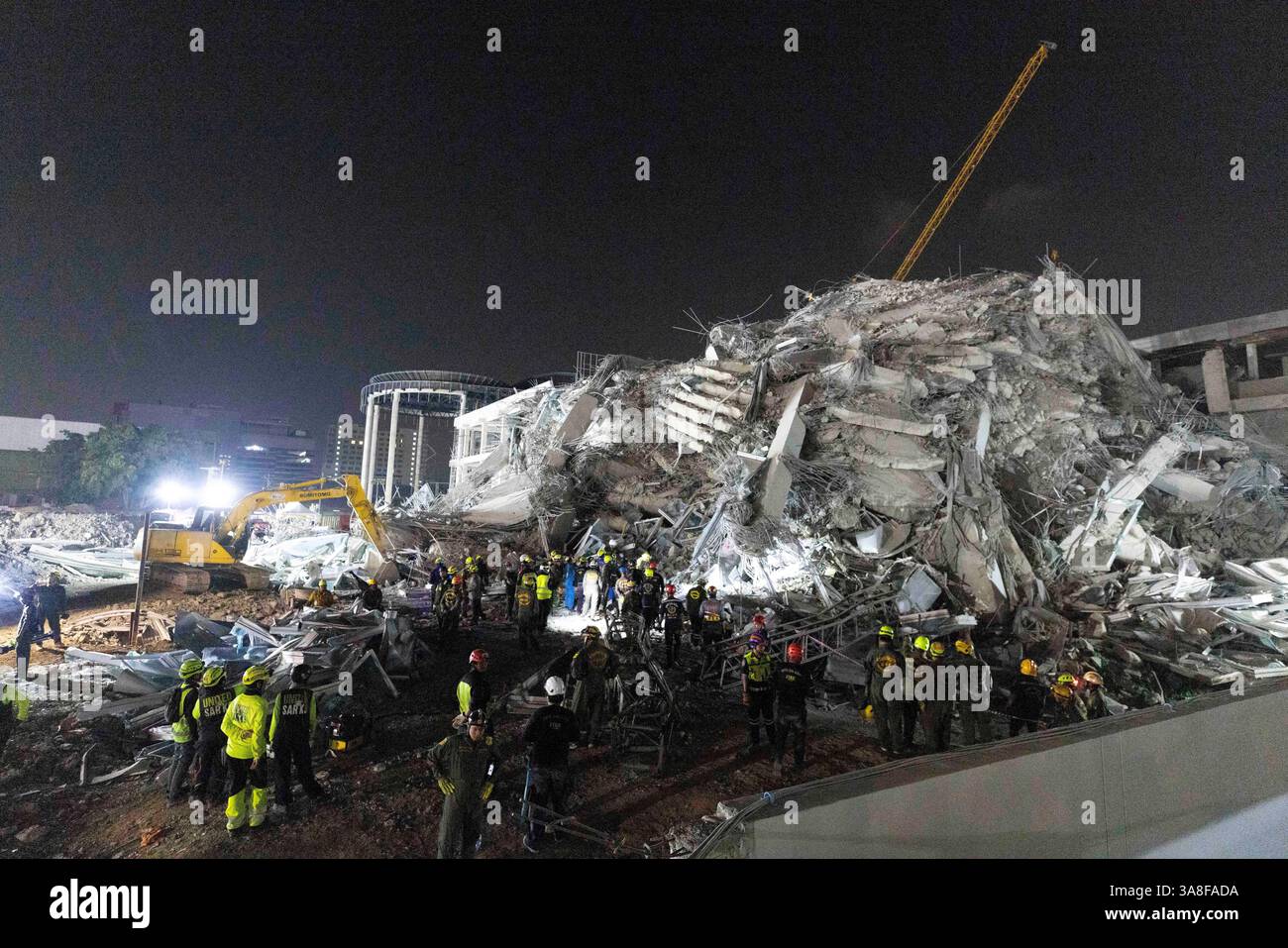 Rescuers search for victims at the site of a high-rise building under ...