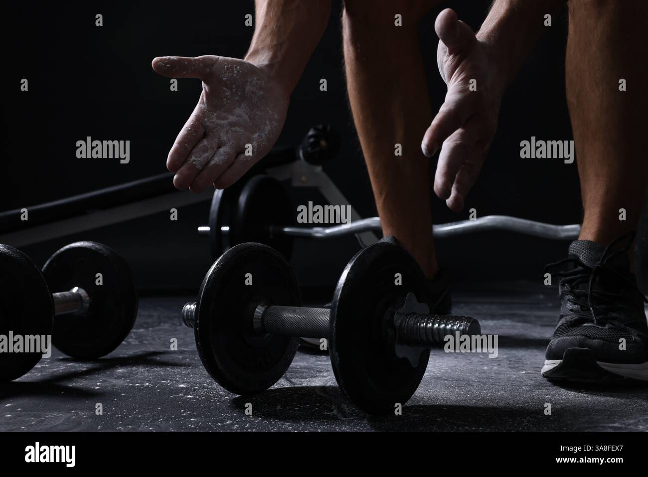 Man clapping hands with talcum powder before training with barbells on ...