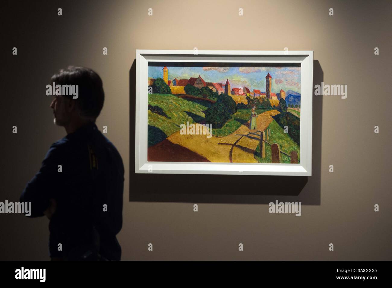 A man walks past the painting title "Vassily Kandinsky, old town II ...