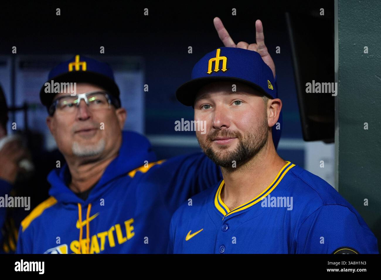 Seattle Mariners bench coach Manny Acta jokes with catcher Cal Raleigh ...