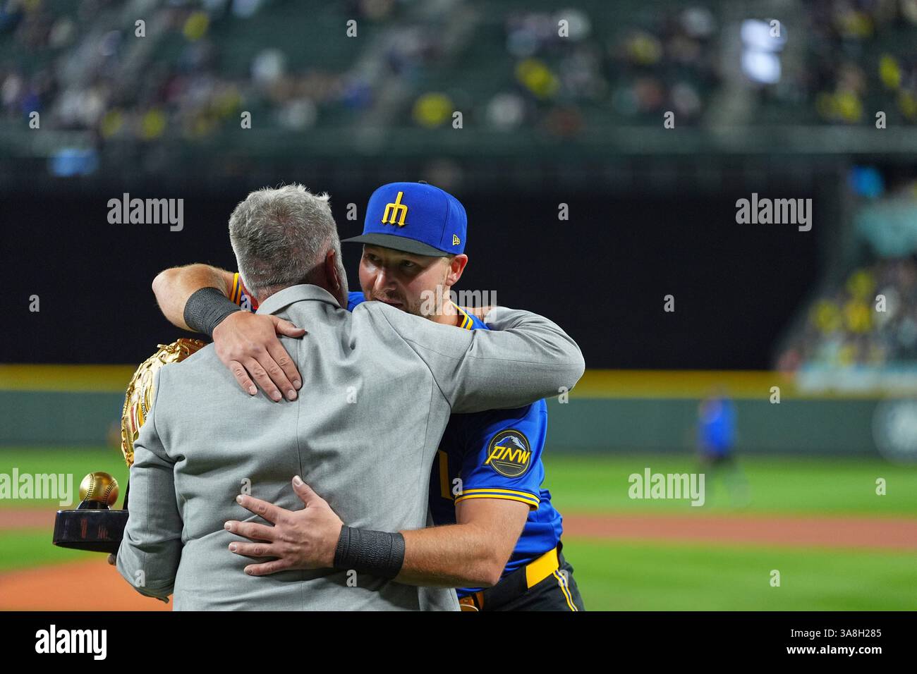 Seattle Mariners catcher Cal Raleigh, facing, hugs father Todd Raleigh ...