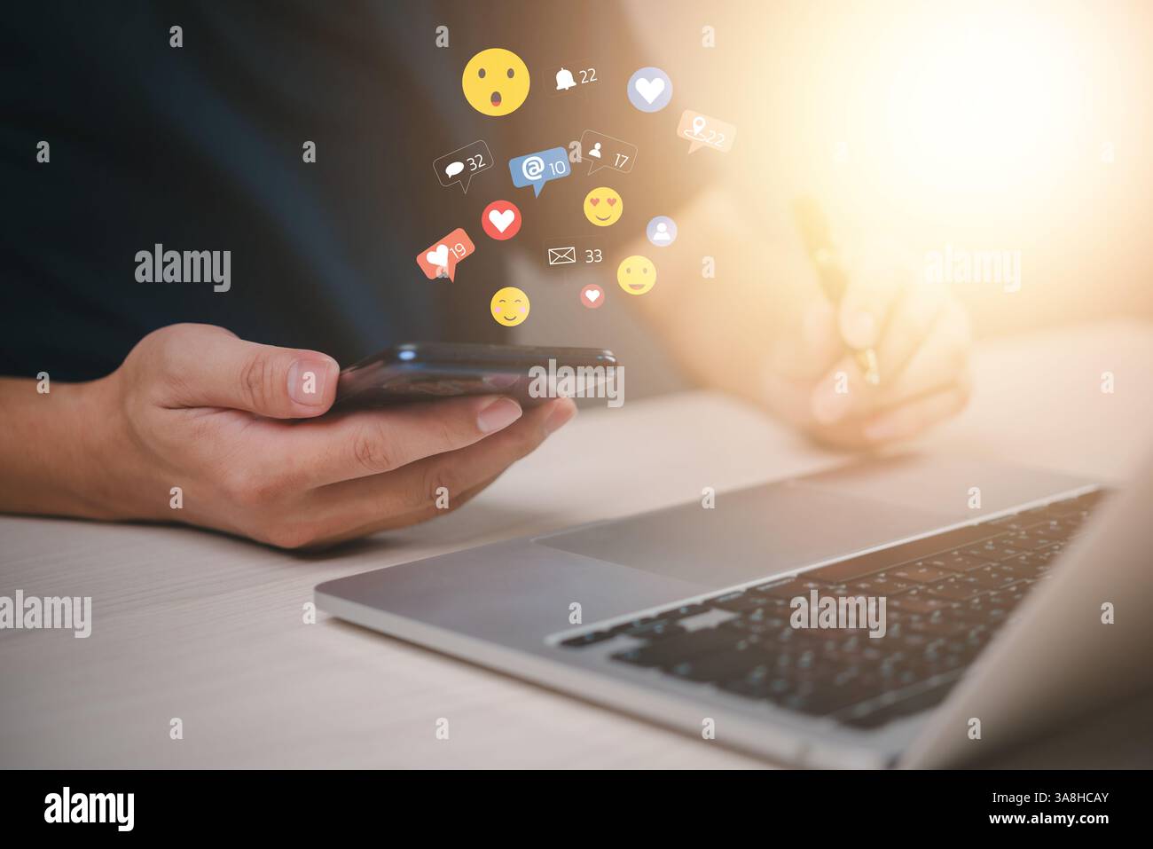 Hands using a smartphone with floating social media icons, representing digital interaction and ...