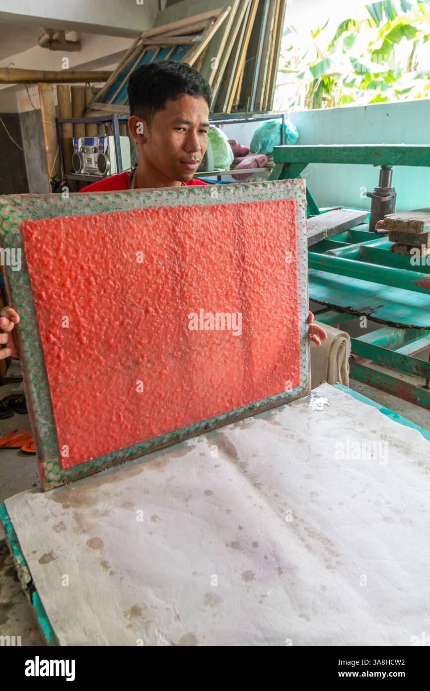 A Filipino man makes handmade paper inside a handicraft shop in Kalibo ...