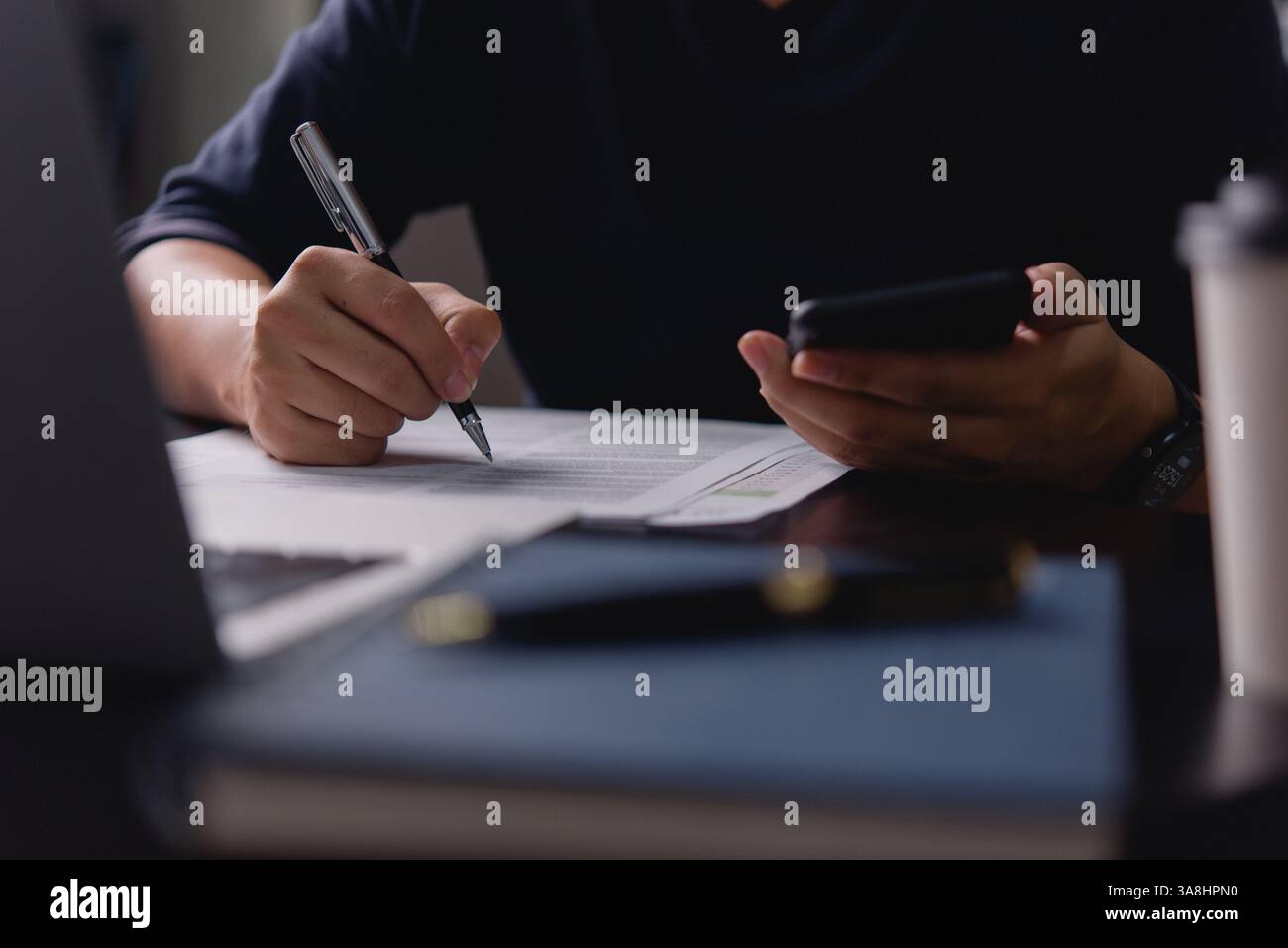 man writing content or a script on a notepad with a pen while holding a ...