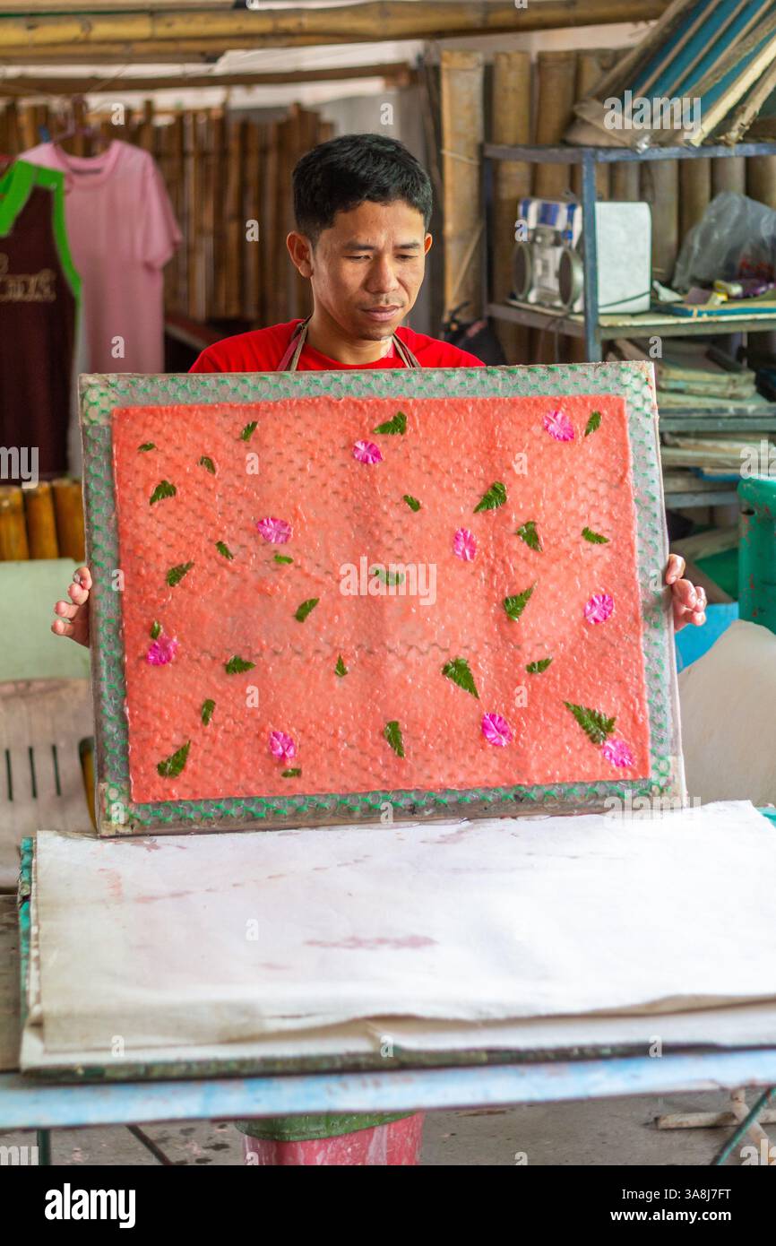 A Filipino man makes handmade paper inside a handicraft shop in Kalibo ...