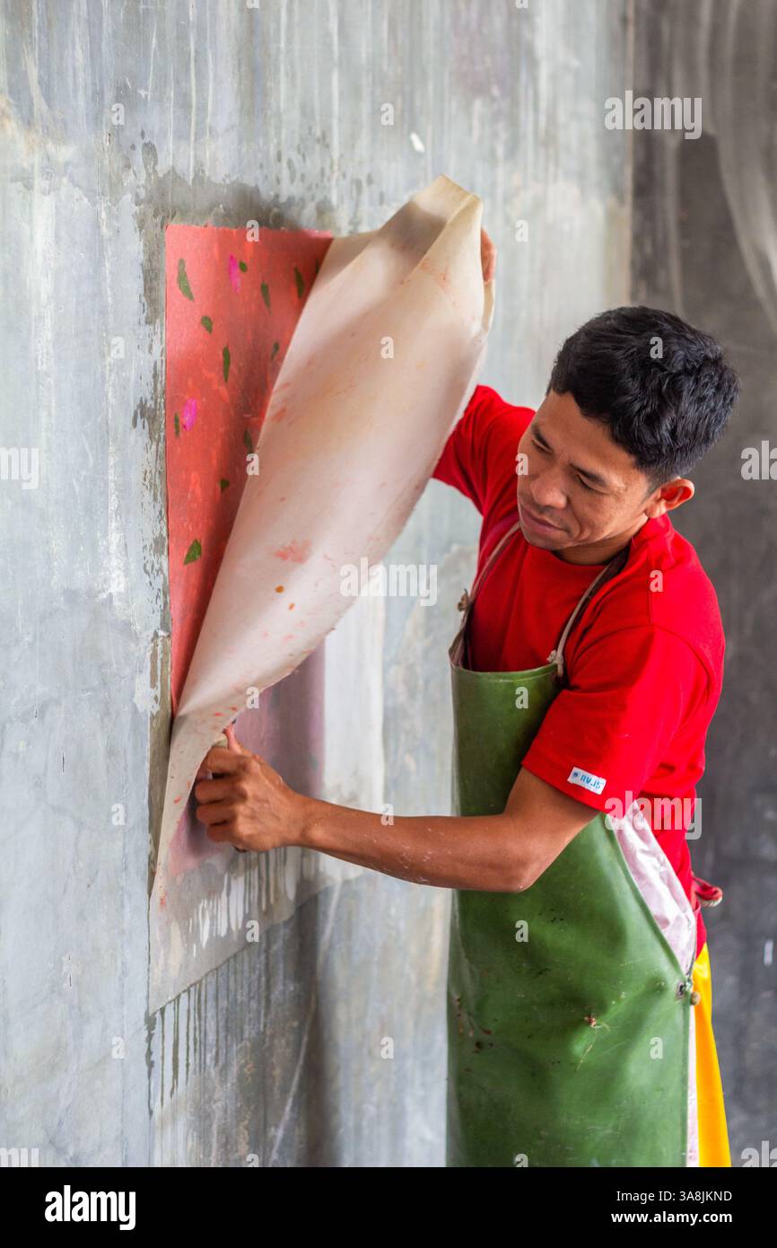 A Filipino man makes handmade paper inside a handicraft shop in Kalibo ...