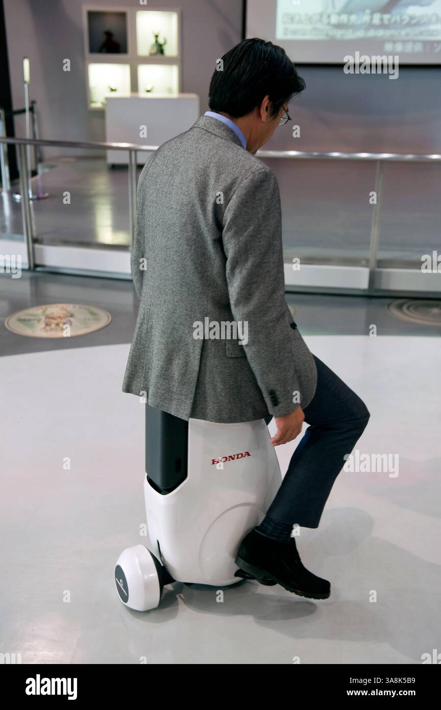 Early model showing rider on Honda's Uni-Cub intuitive transport ...