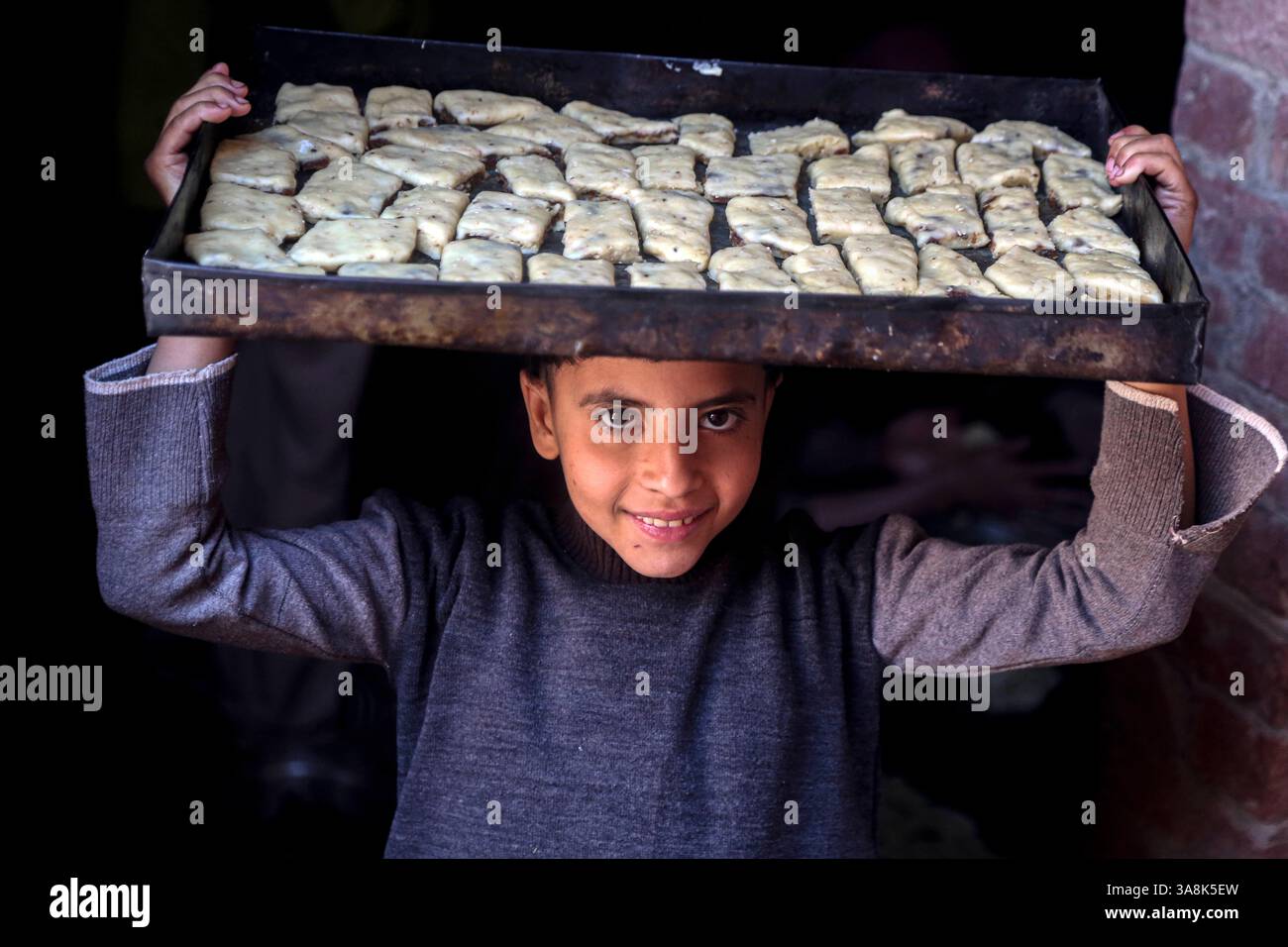 Beijing, Egypt. 27th Mar, 2025. A child carries a tray of traditional ...