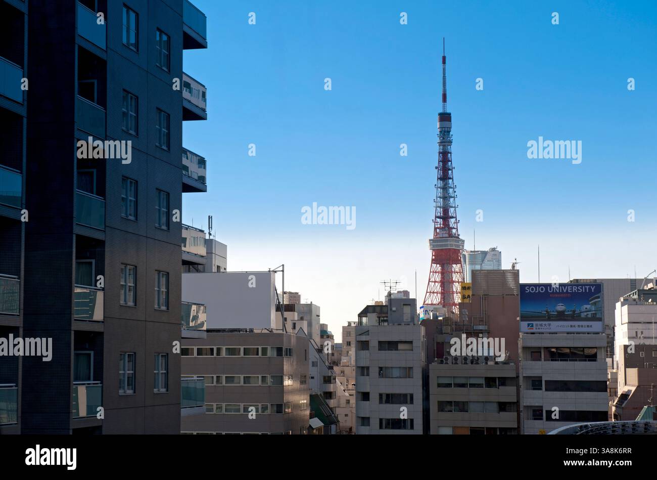 Tokyo Tower rising high above the crowded urban sprawl of the concrete jungle revealing a ...
