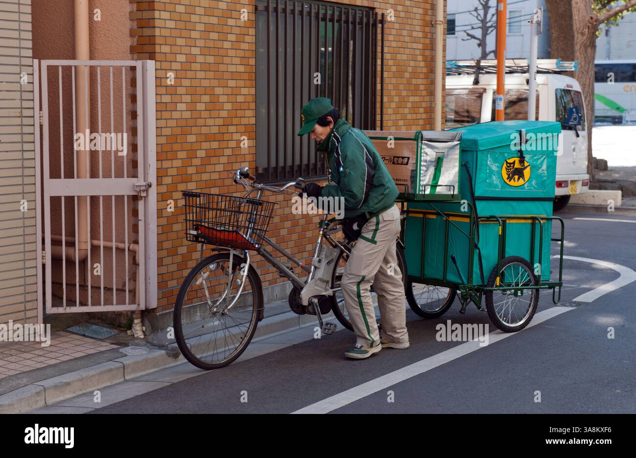 A Yamato Transport Kuroneko (Japan Black Cat Transport) delivery man ...