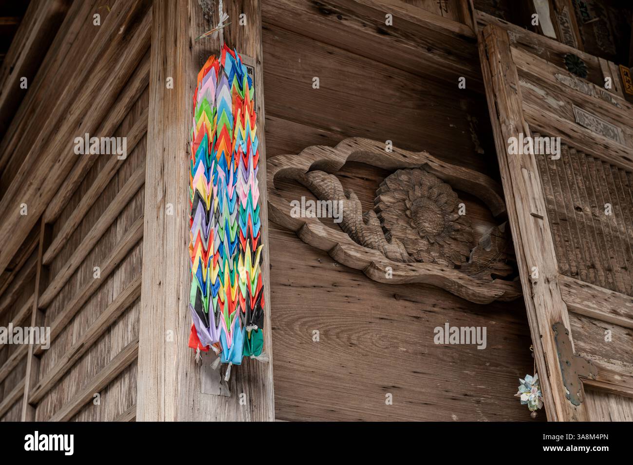 Folded paper cranes hanging on a wooden building at Iwamotoji (or ...