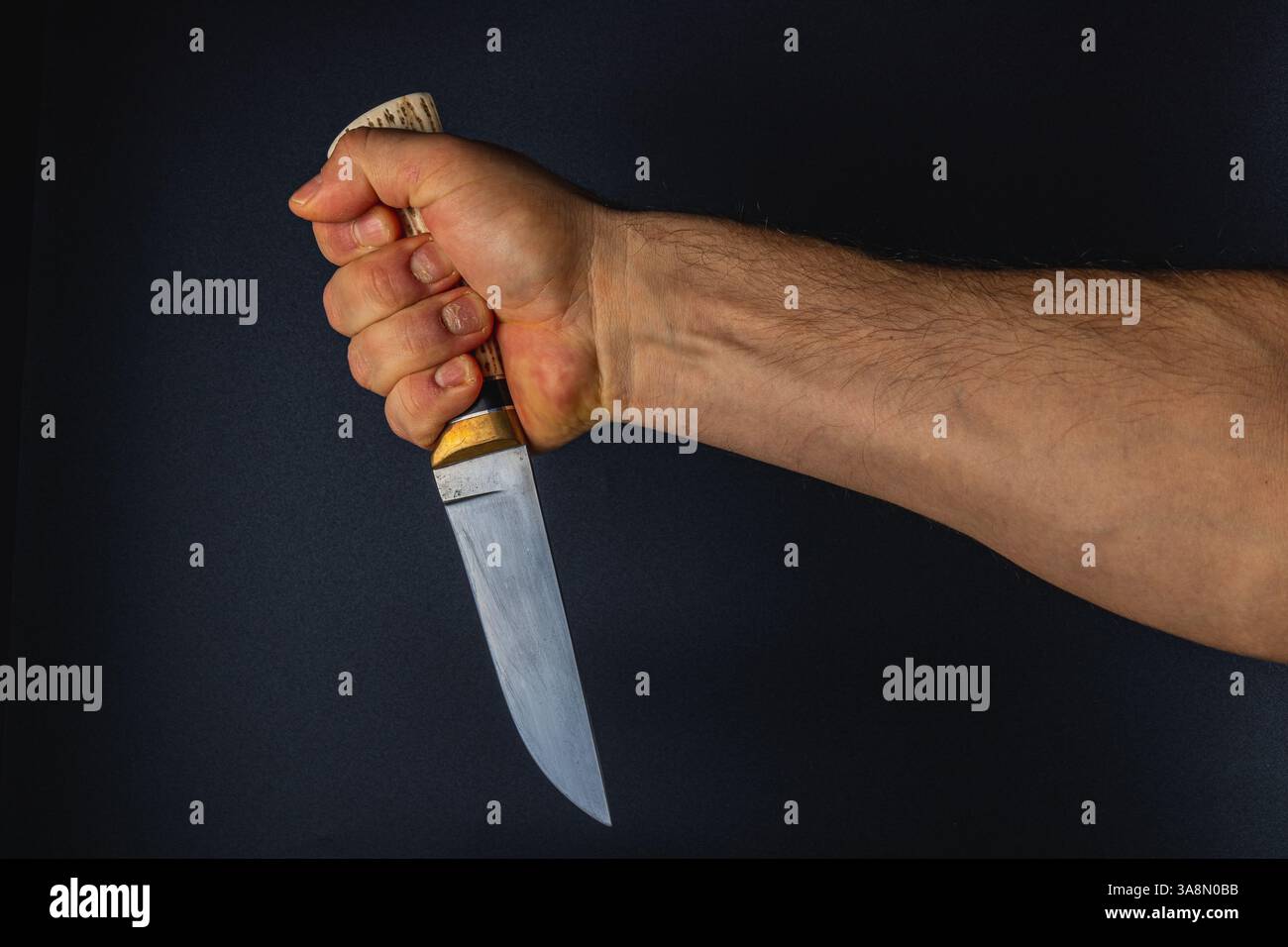 A hand firmly holds a knife with a wooden handle, showcasing defined ...