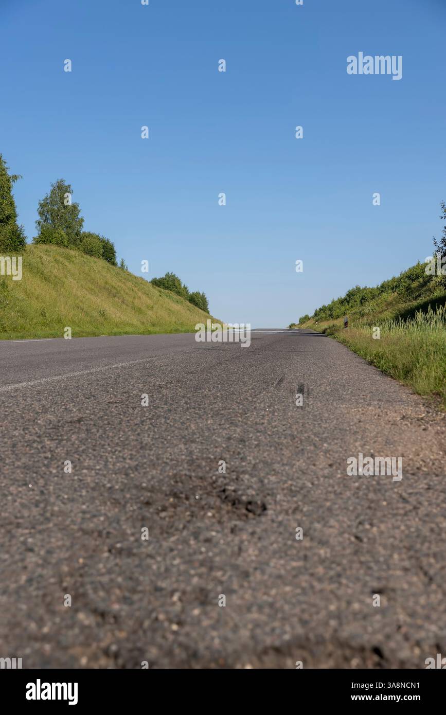 a straight paved road against a blue sky background, a highway in a ...