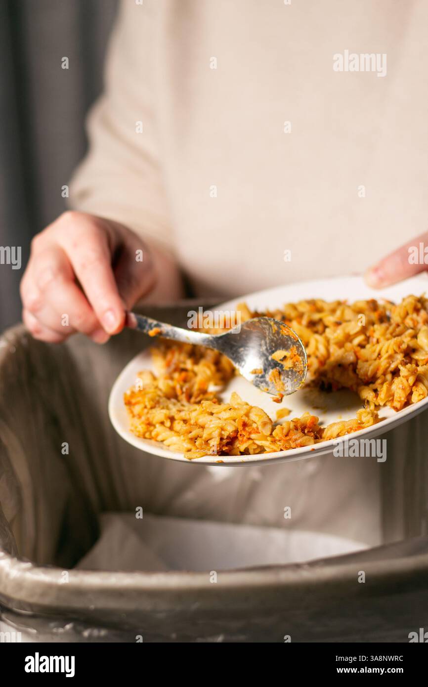 Vertical image of woman throwing away bio trash with food leftovers ...