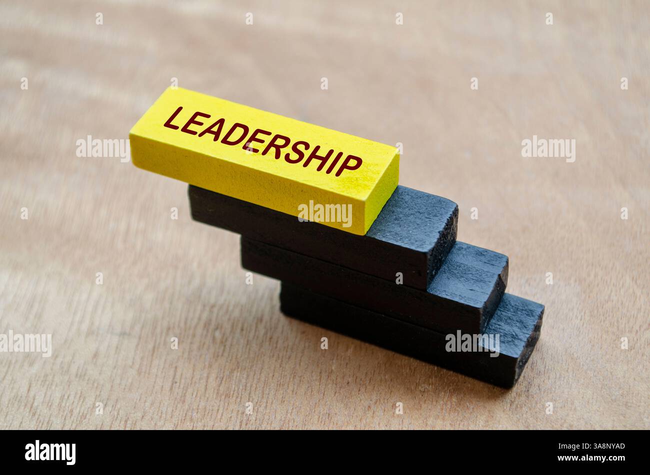 Leadership text on yellow wooden block stacking on other black wooden ...