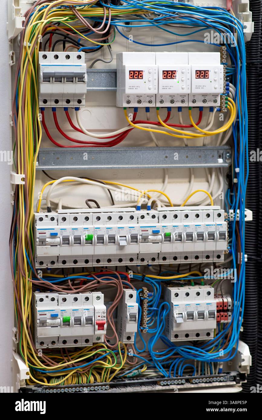 Electrical panel with circuit breakers, wiring, and voltage indicators ...