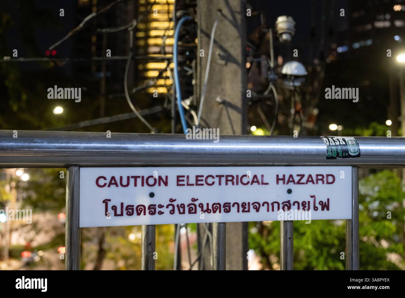 A Caution Electrical Hazard sign near an electricity pylon with exposed ...