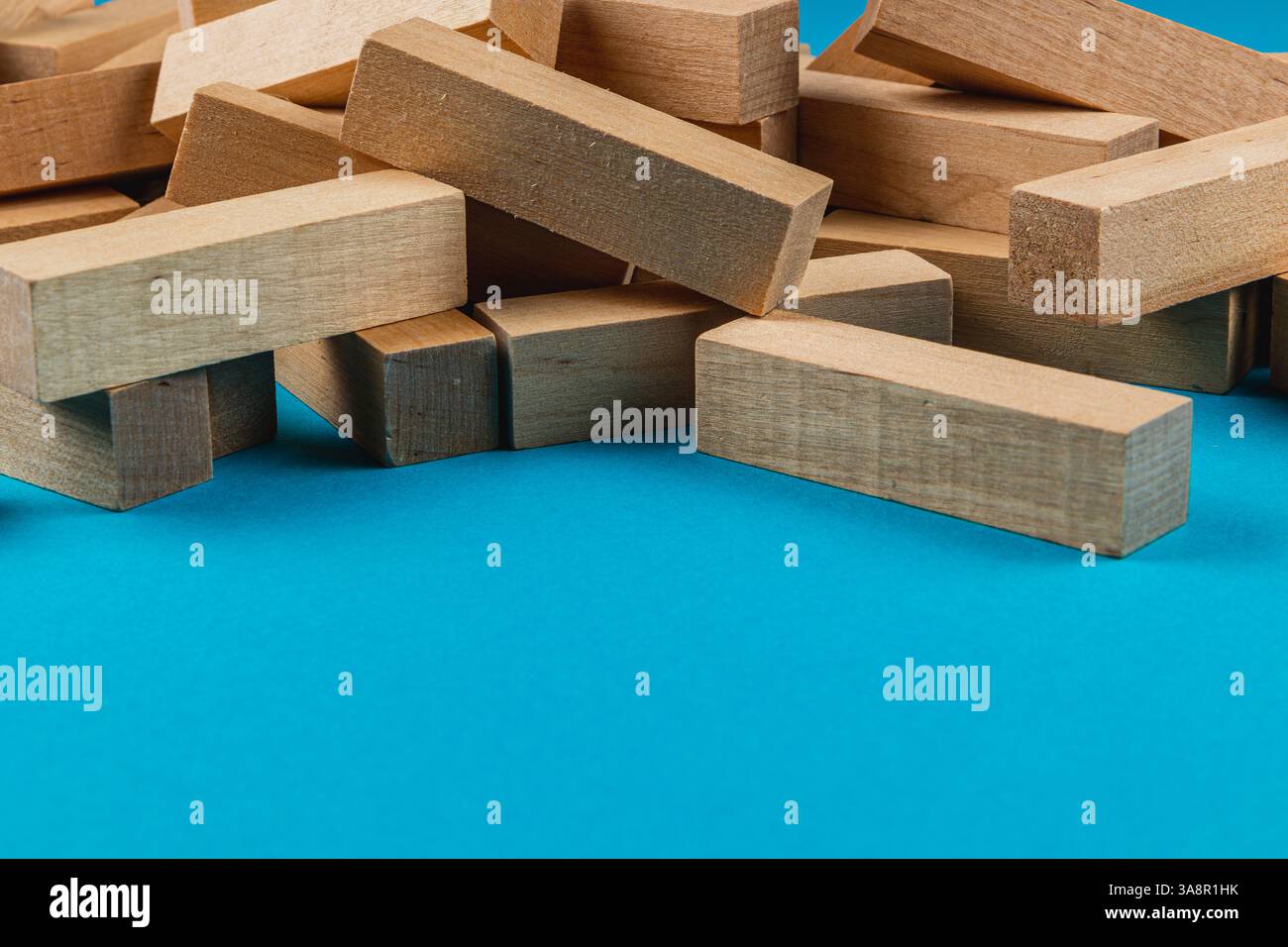 Various wooden blocks lay scattered across a bright blue surface ...