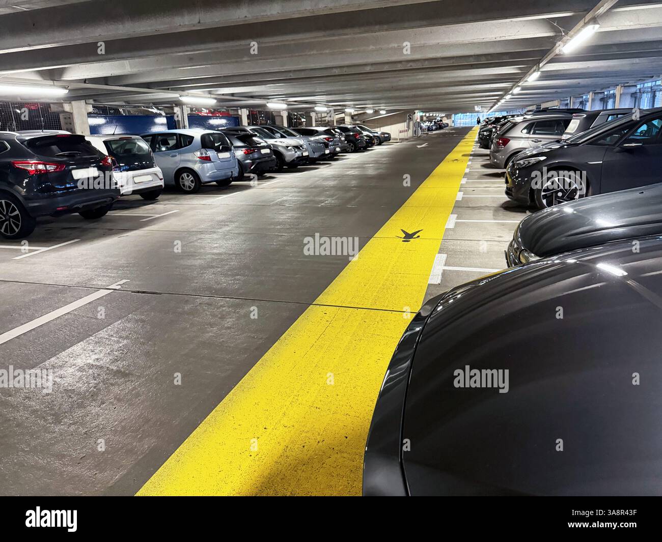 Many parked cars in underground garage of apartment complex Stock Photo ...