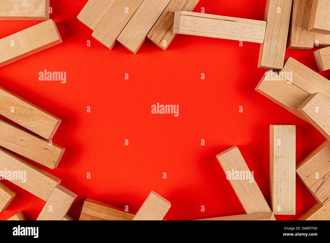Wooden blocks are scattered on a bright red surface, showcasing a ...
